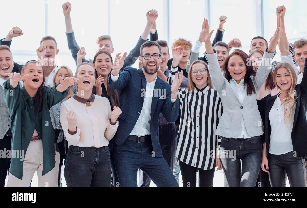 happy group of young employees with hands up Stock Photo - Alamy