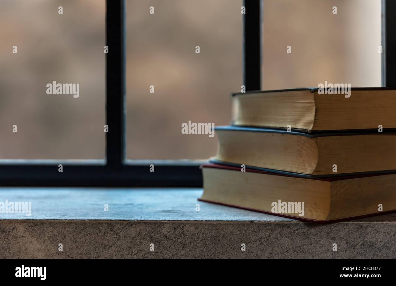 Books stack on a window sill. Closed old notebooks on stone background ...