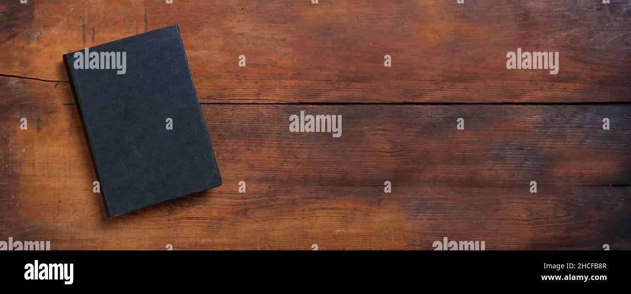 Blank cover book on a table. Closed old black hardcover notebook on ...