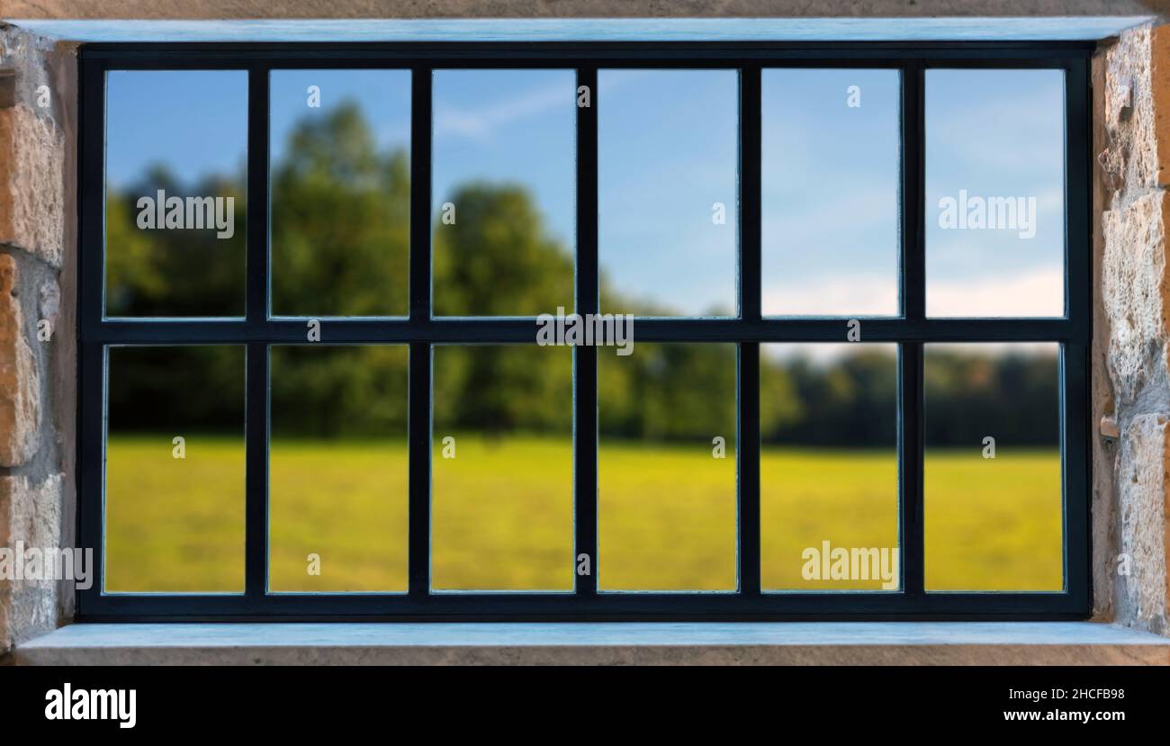 Metal frame window on a stone wall. Black color aluminum grid, blur ...