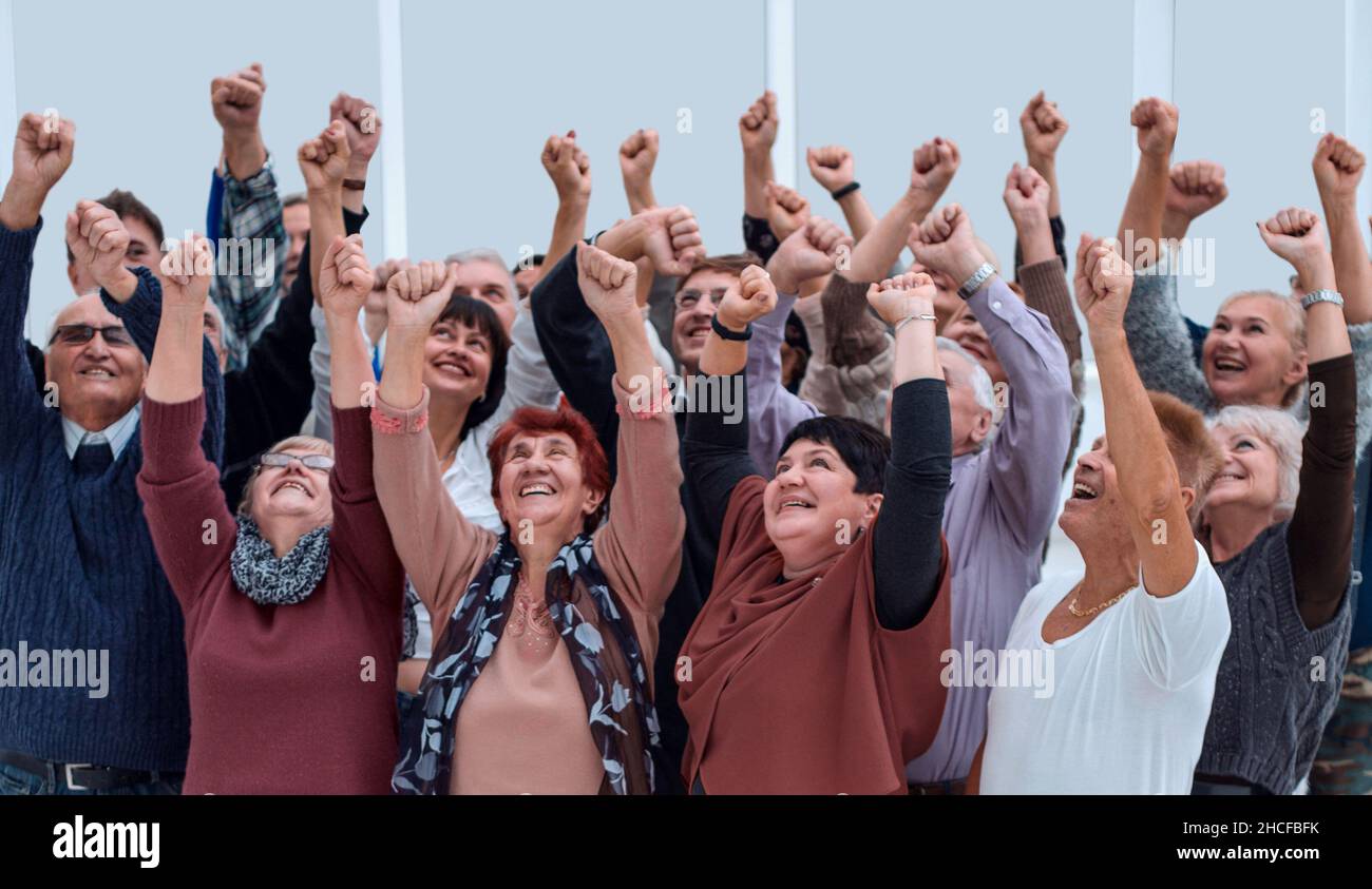 a group of elderly people raised their hands up Stock Photo - Alamy