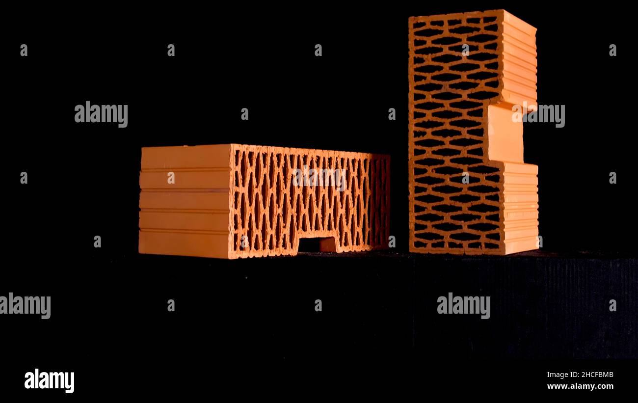 Small pile of red ceramic blocks moving slowly isolated on black ...