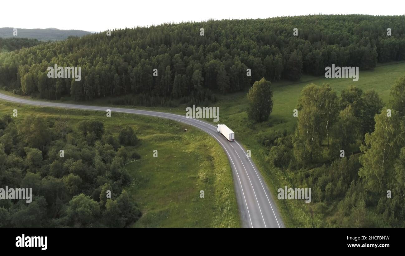 Wagon driving on the highway surrounded by green trees, aerial view ...