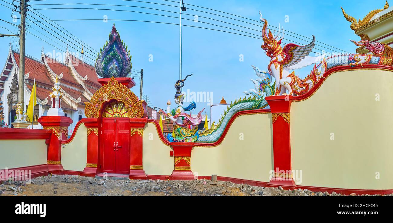 The scenic gate and fence of historic Wat Muentoom temple, decorated ...