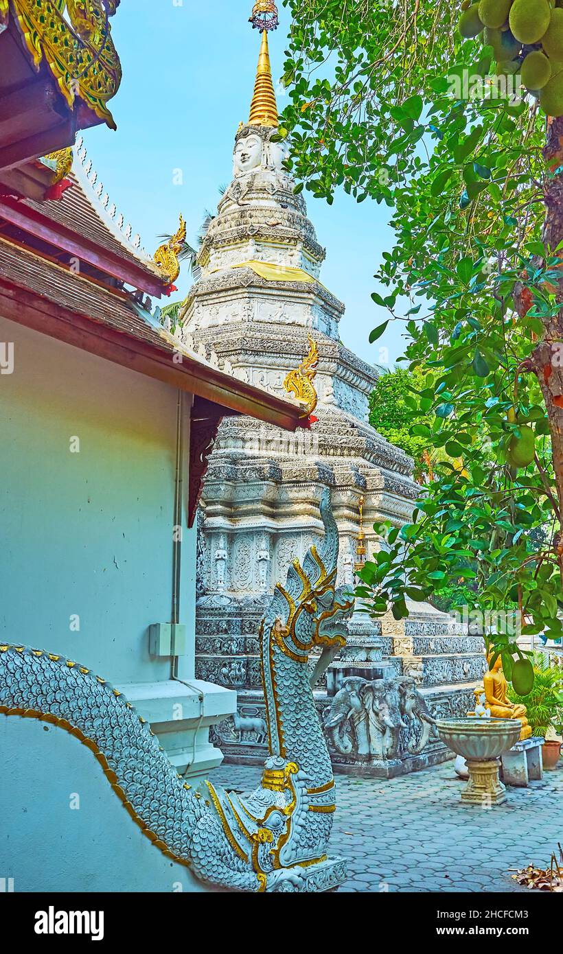 The ornate chedi of Wat Phan Waen temple behind the sculptures of ...