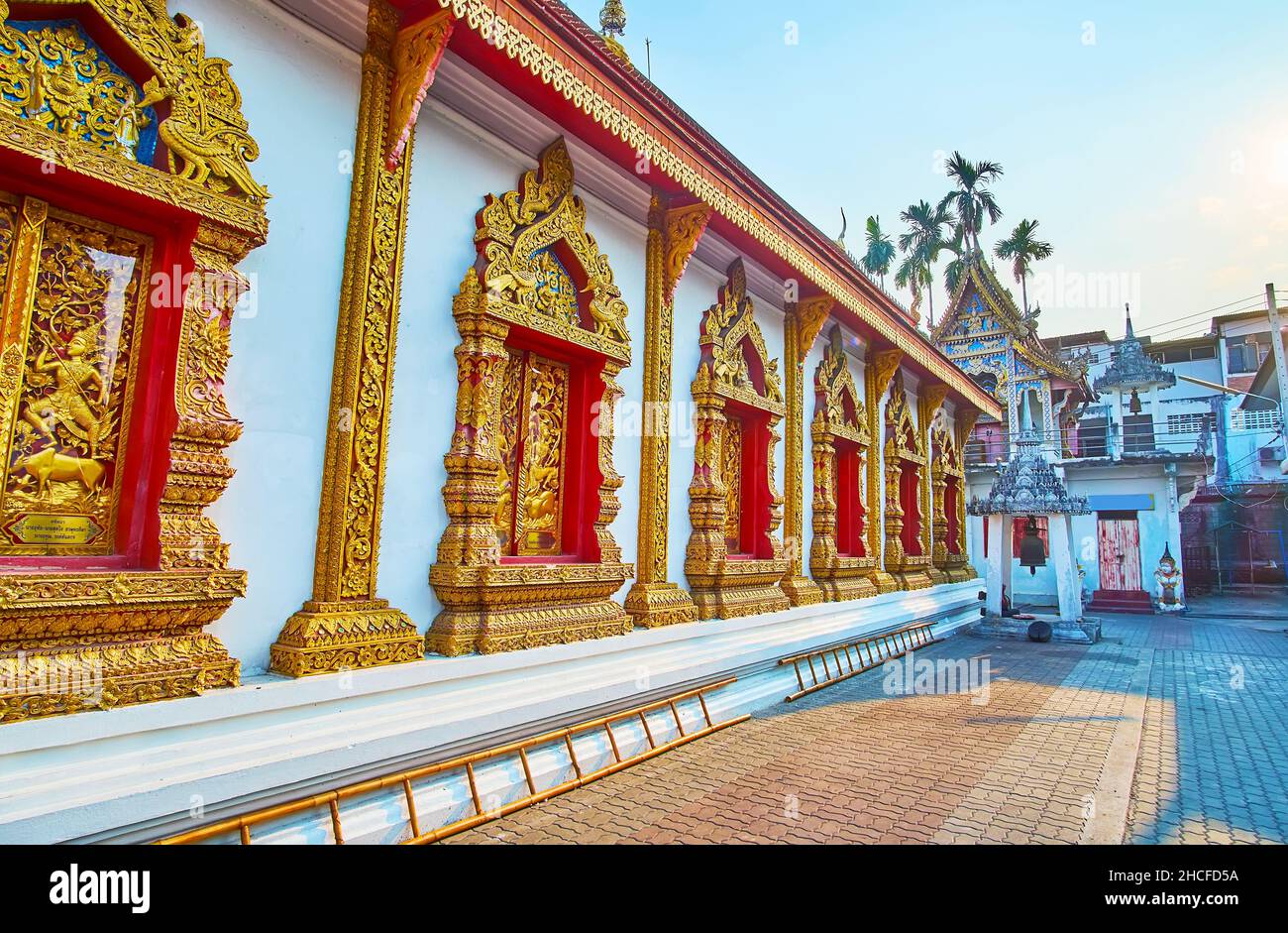 The Viharn wall is decorated with carved gilt pillars and window frames ...