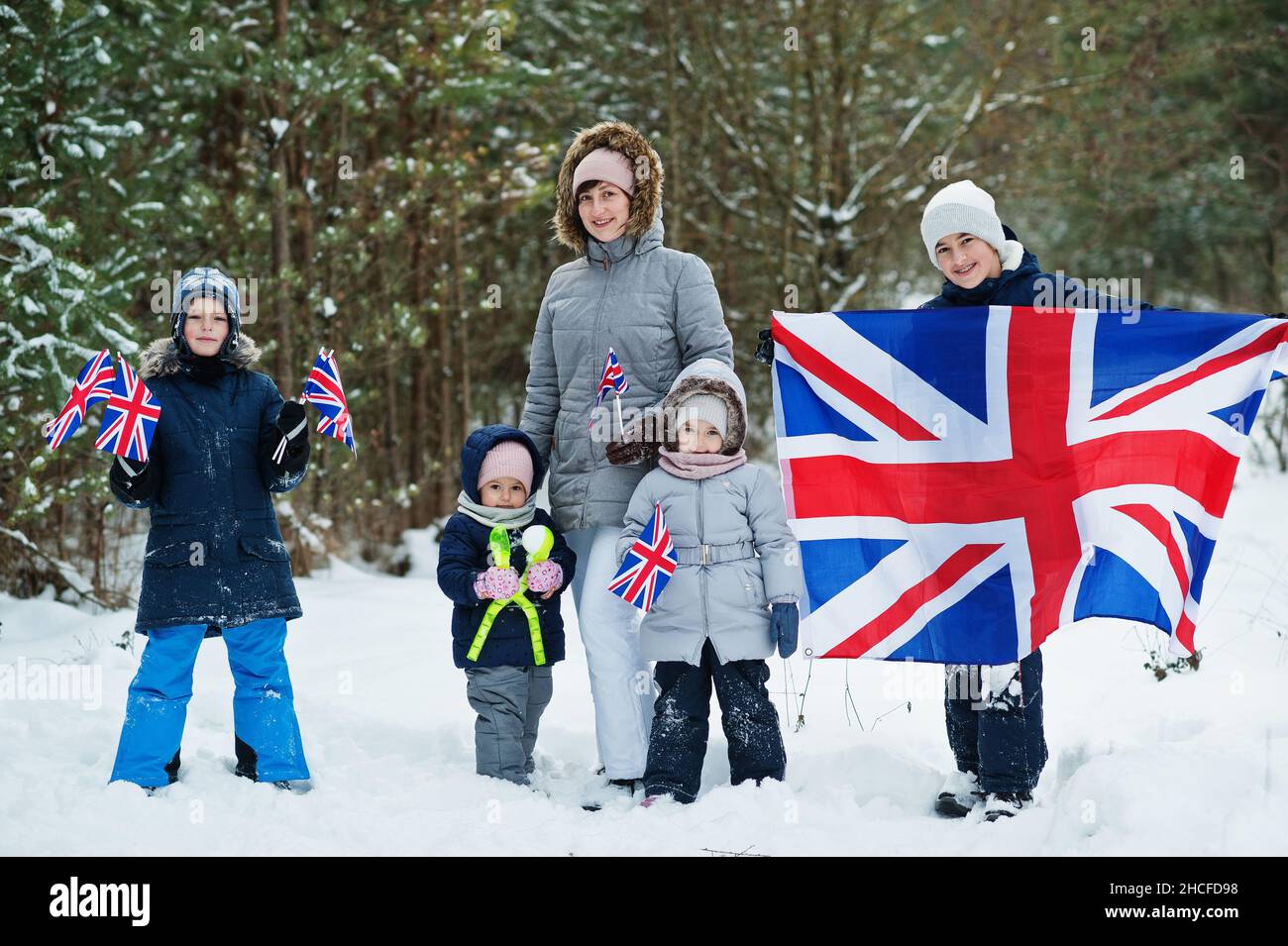 Mother with kids holding flag of Great Britain on winter landscape ...