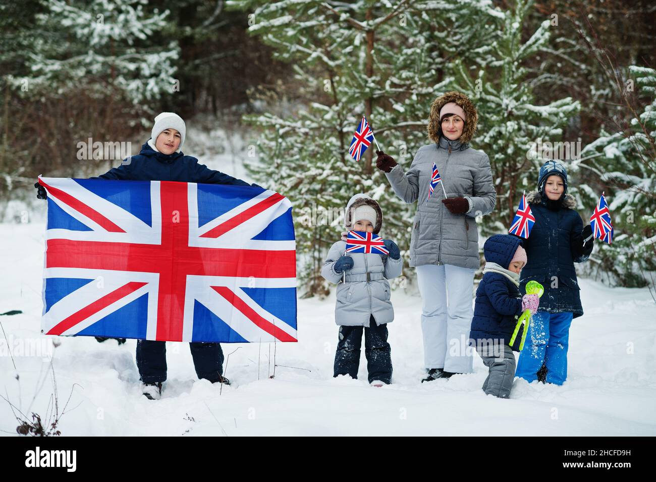 Mother with kids holding flag of Great Britain on winter landscape ...