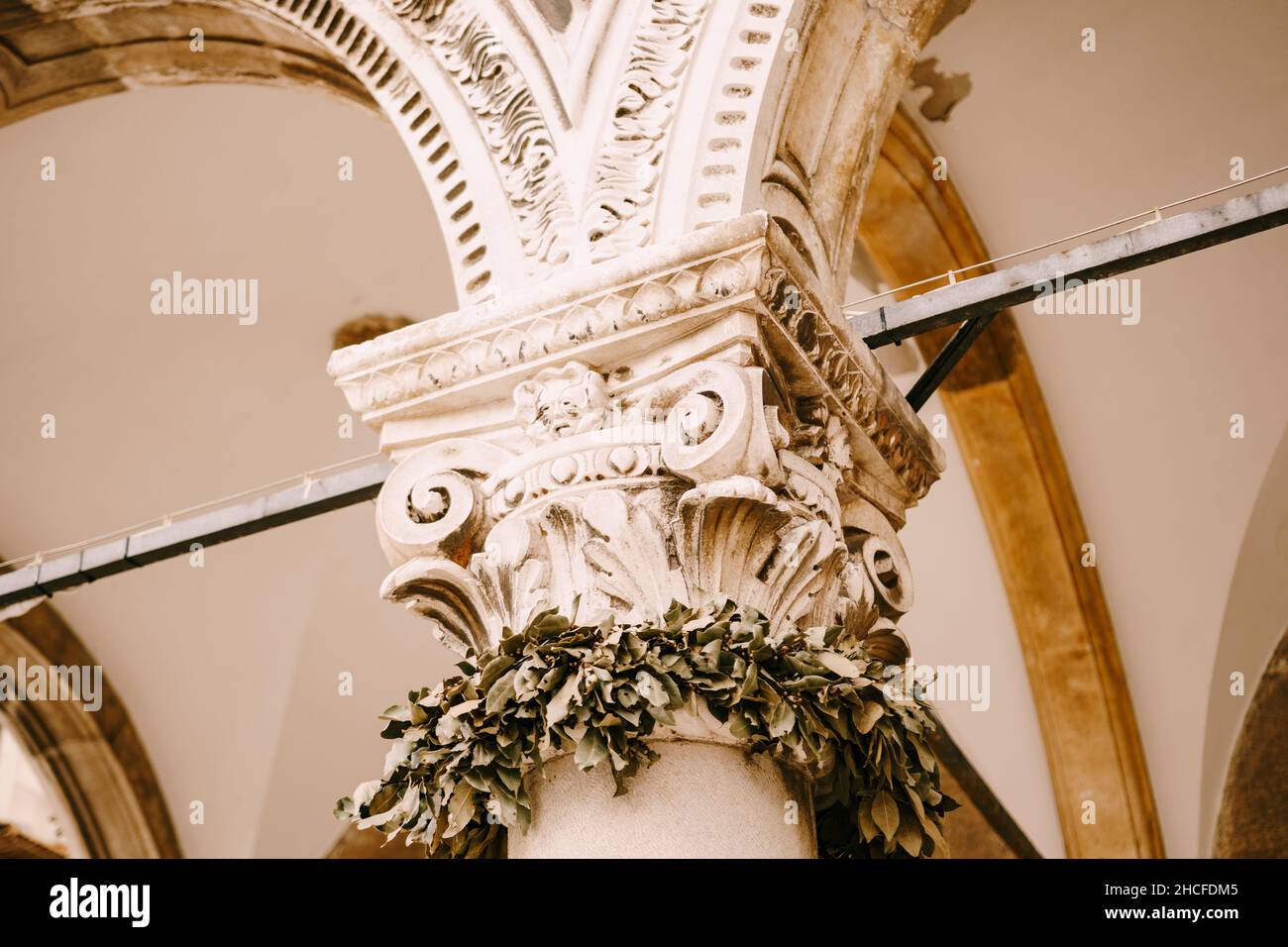 Fragment of a carved white marble column under the vaulted ceiling ...