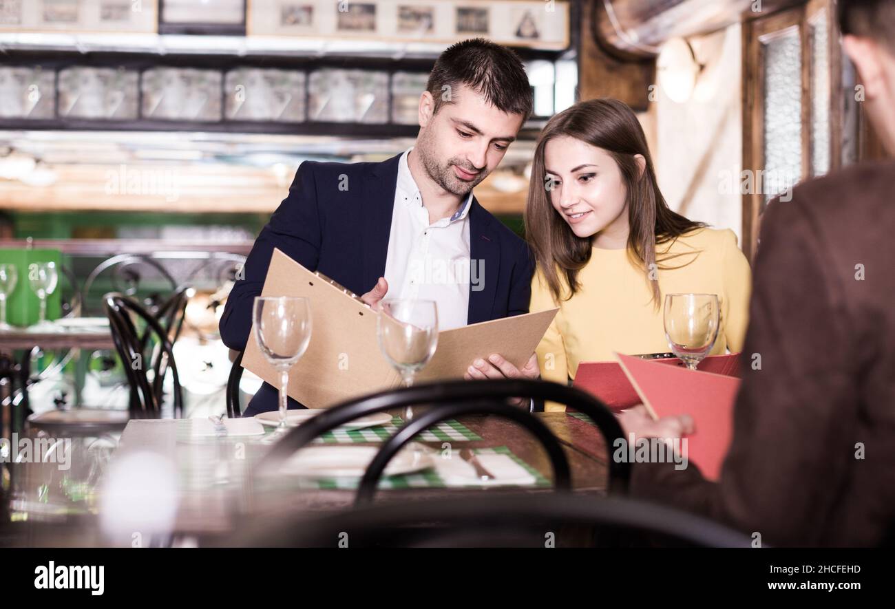 Female and male are looking in menu for order dinner Stock Photo - Alamy
