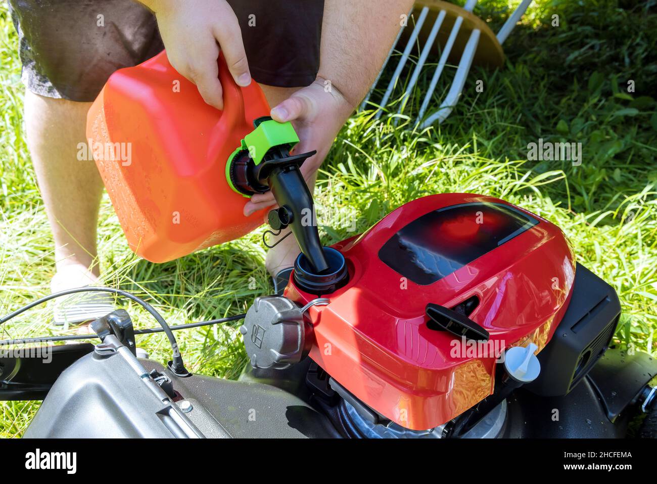 Pouring gasoline gallon refueling into the tank of lawnmower Stock ...
