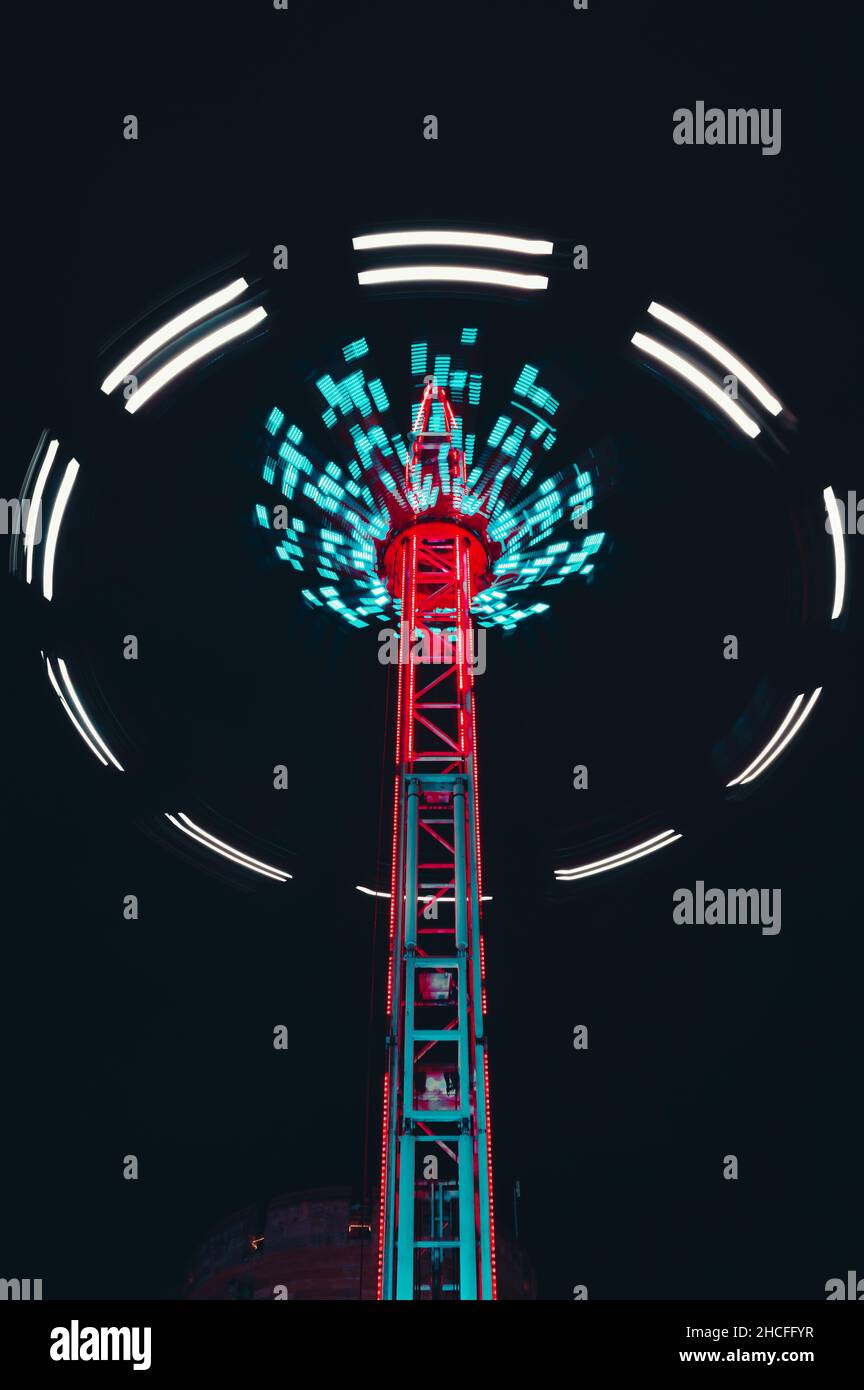 Spinning fair ride at night with bright lights Stock Photo - Alamy