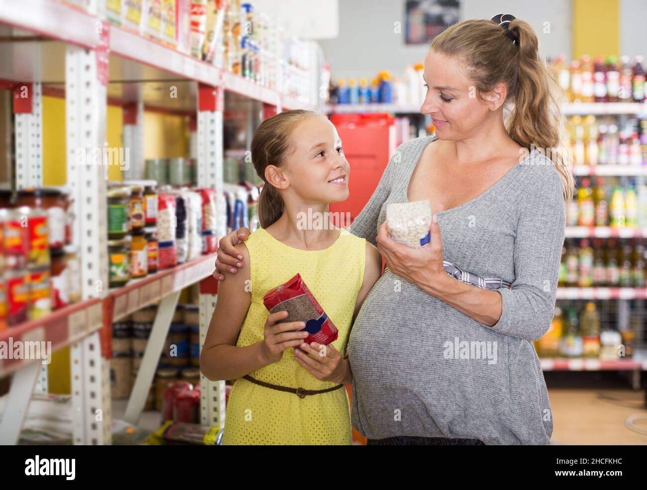 Female with girl choosing goods in food department Stock Photo - Alamy