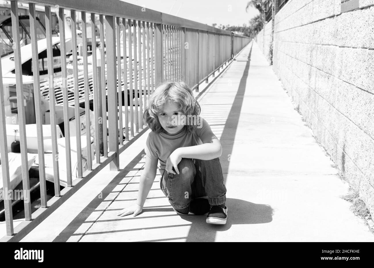 Boy child take short break hunkering down on promenade, rest Stock ...