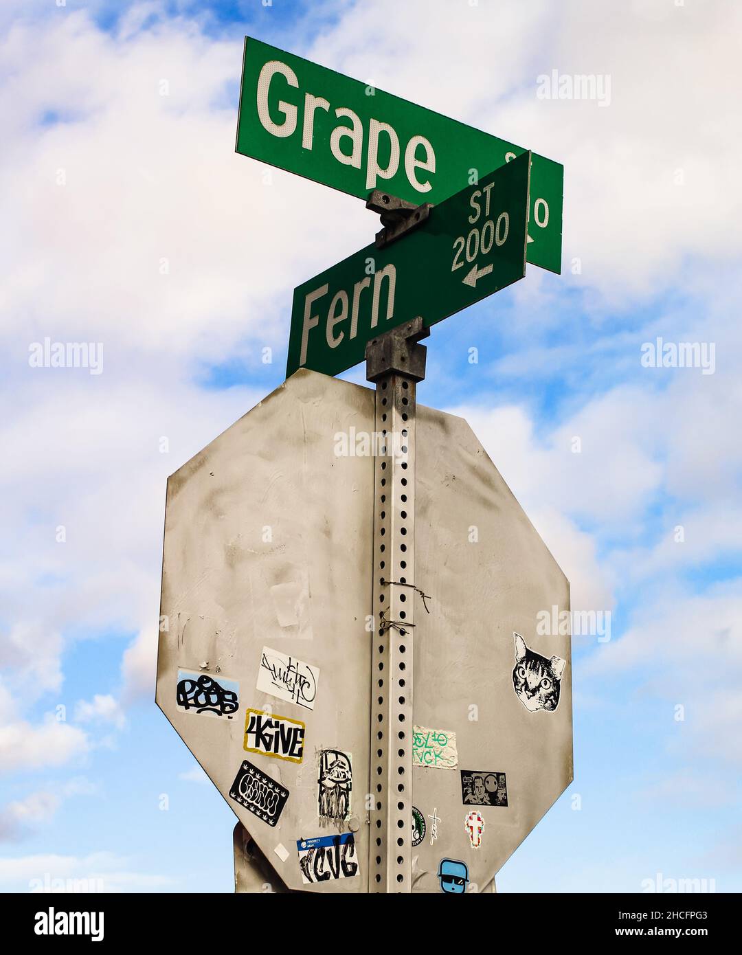 Street intersection sign/back of stop sign with stickers tagged on it ...