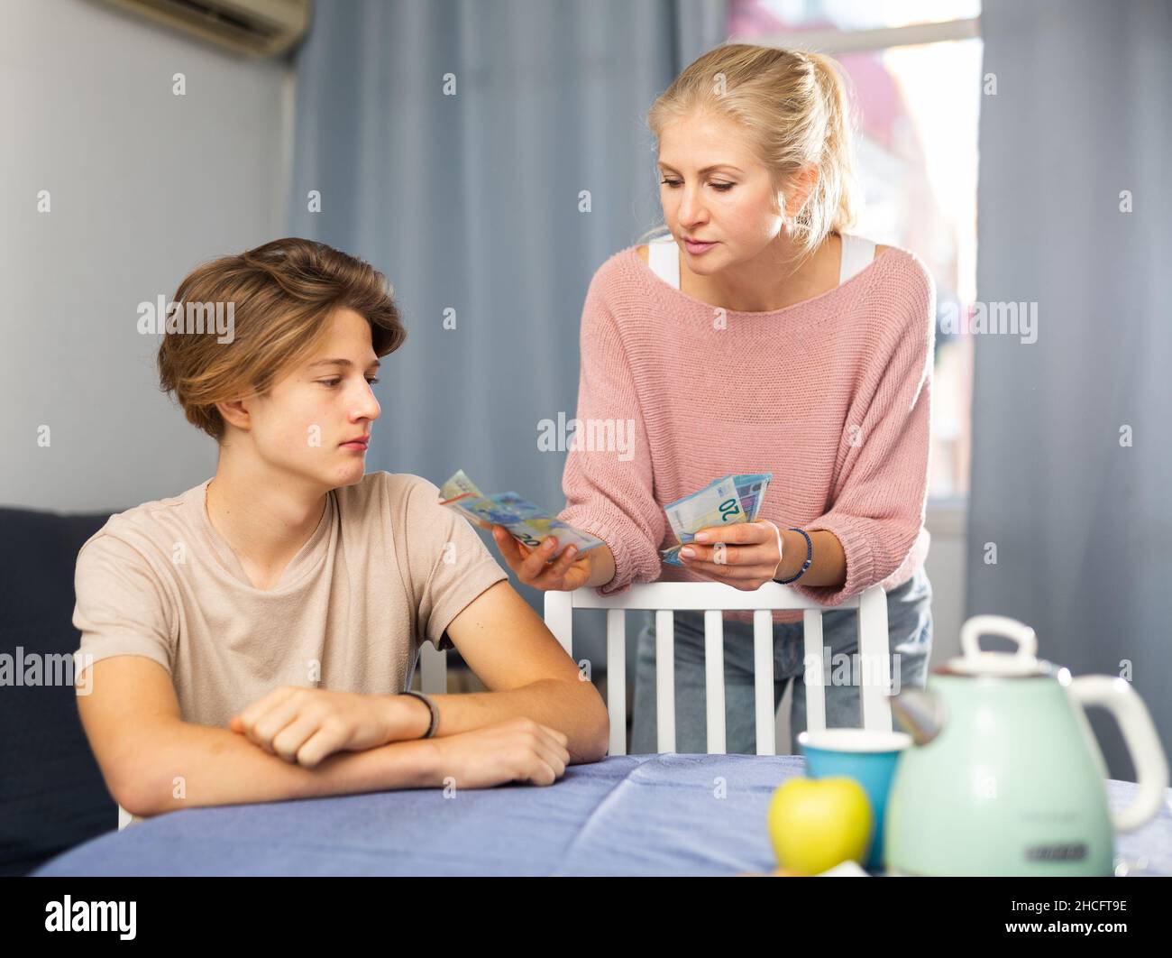 Woman giving money to son hi-res stock photography and images - Alamy