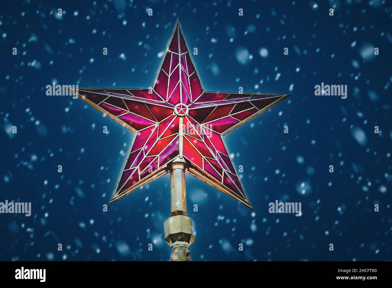 Moscow Kremlin star at night in winter, falling snow in dark blue sky ...