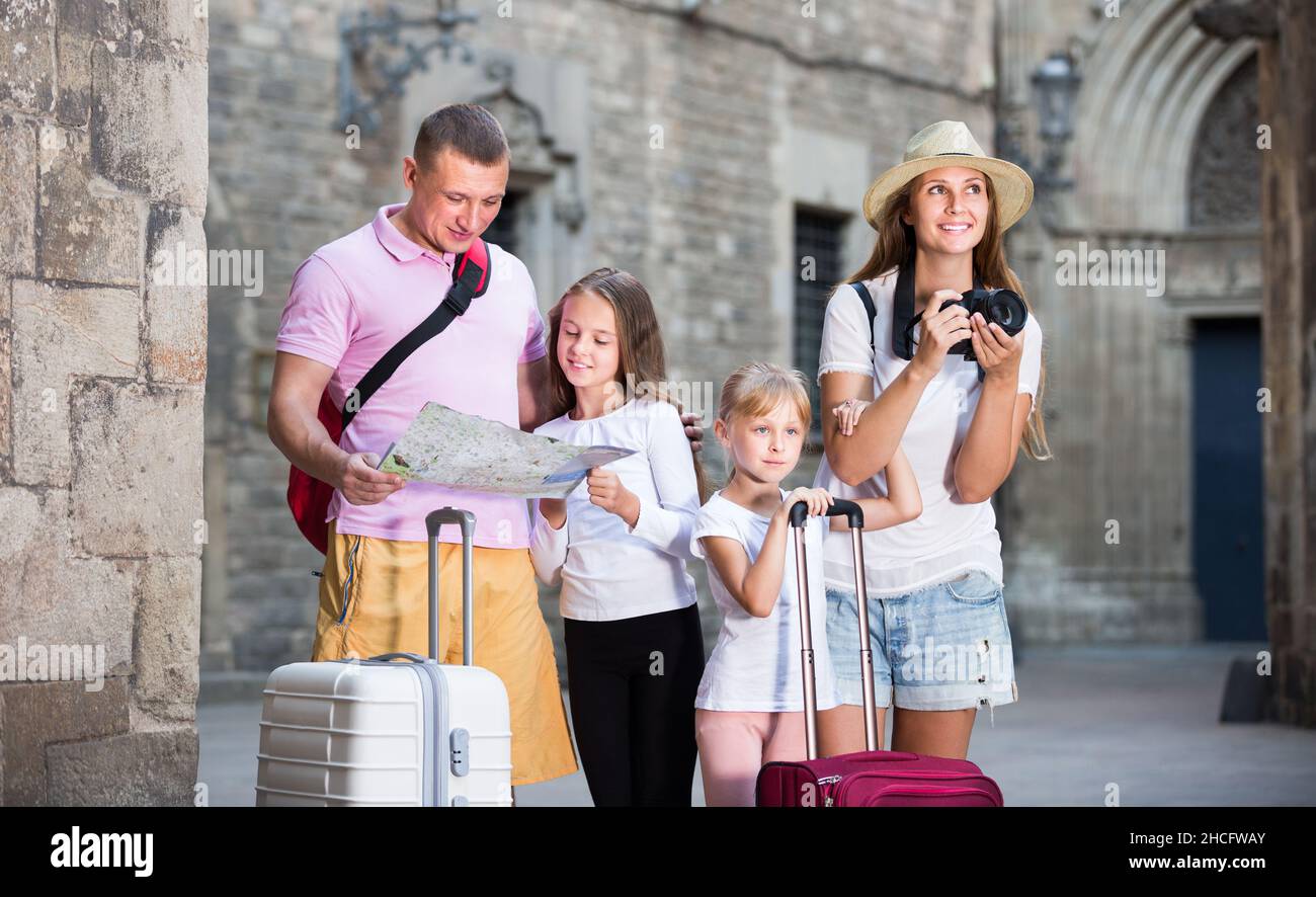 Happy family with children walking with camera and map Stock Photo - Alamy