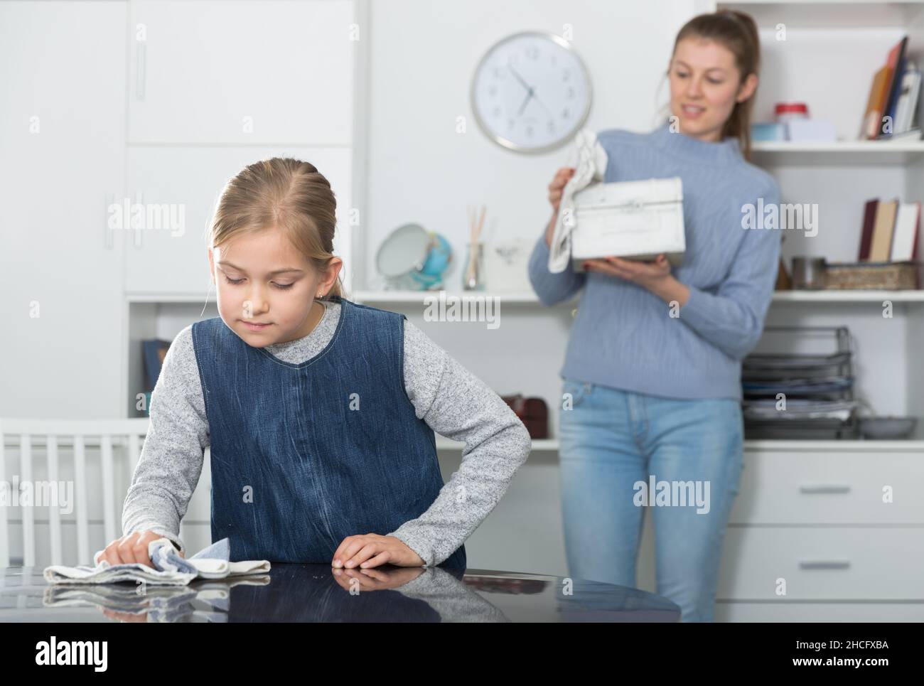 Mother and daughter dusting furniture Stock Photo - Alamy
