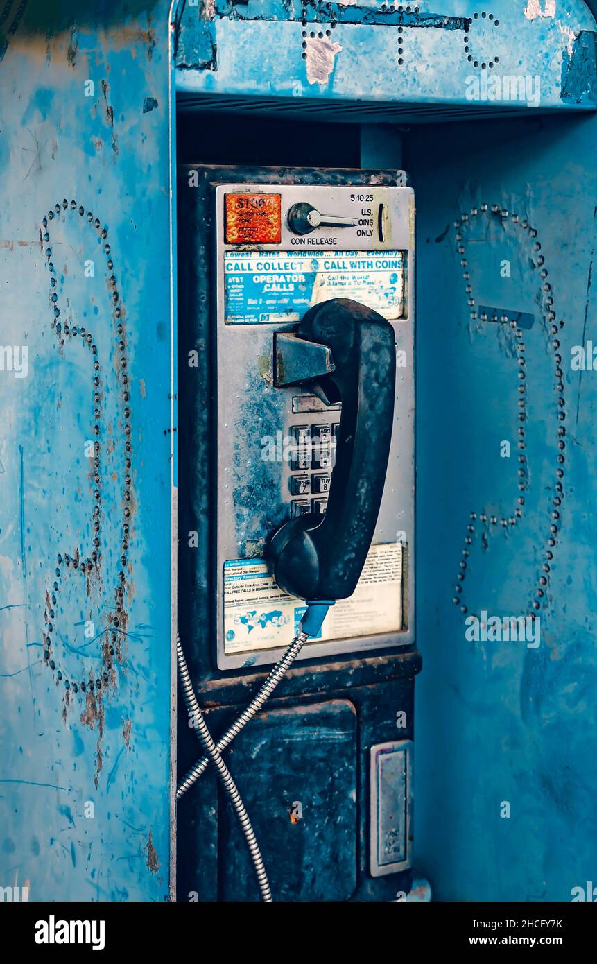 A coin-operated public telephone also called a payphone, hangs on the ...
