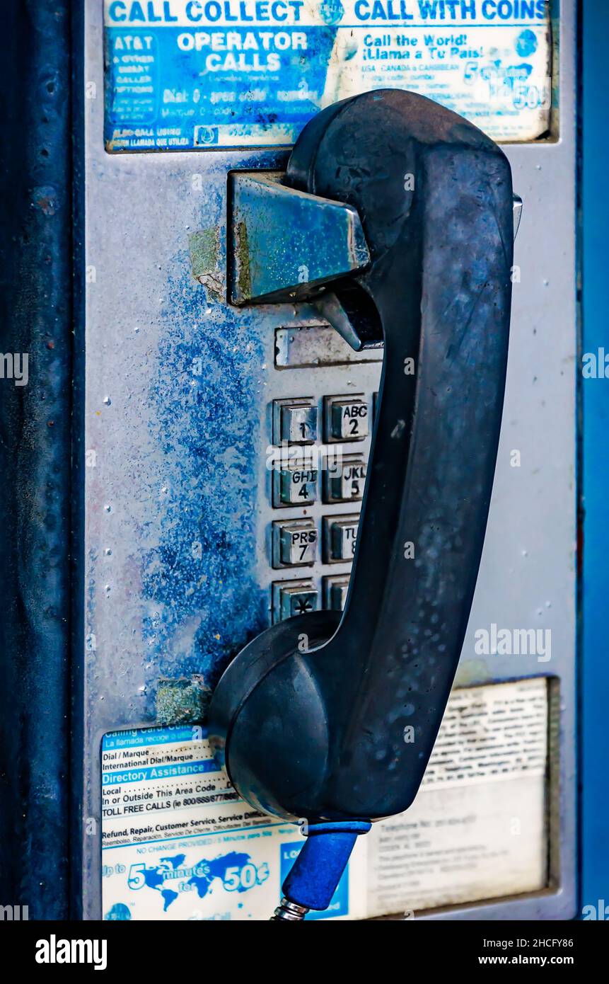 A coin-operated public telephone also called a payphone, hangs on the ...