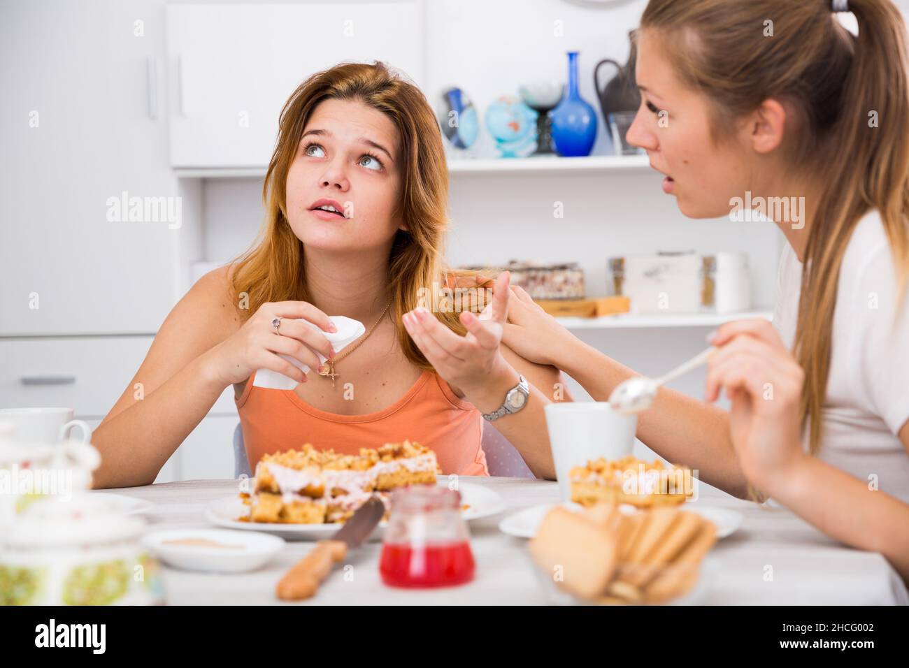 Female talking with young sad friend at home Stock Photo - Alamy