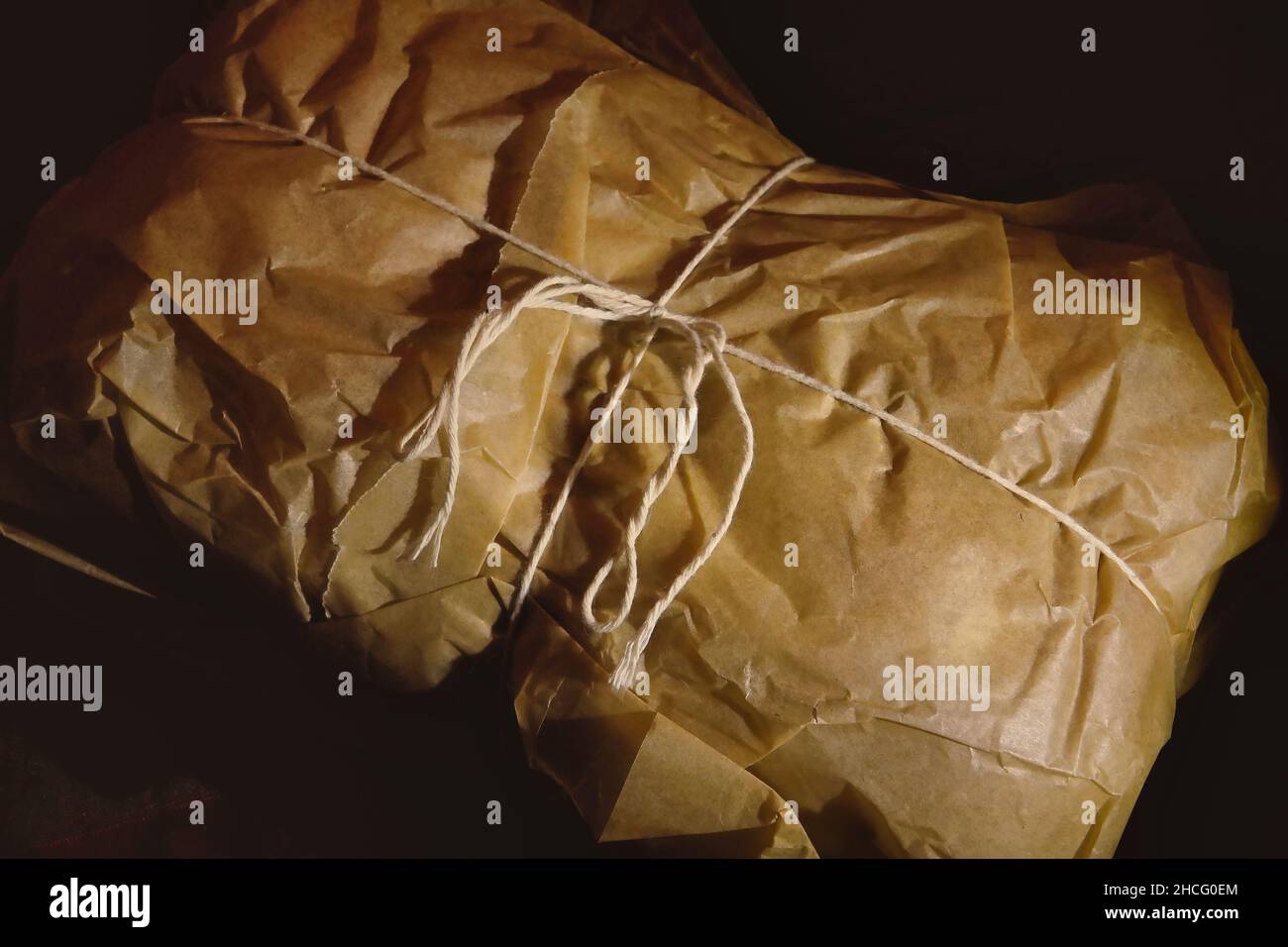 A plain brown paper parcel wrapped and tied with string awaits pick-up ...