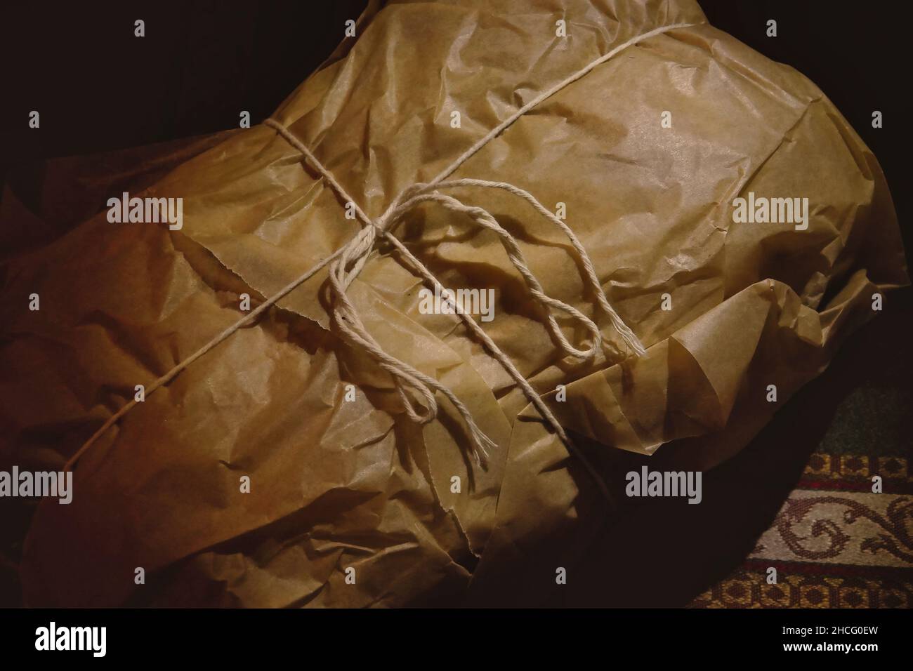 A plain brown paper parcel wrapped and tied with string awaits pick-up ...