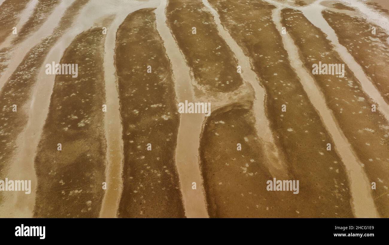 Patterns in the sand of the ocean bed at low tide on a beach, drone ...