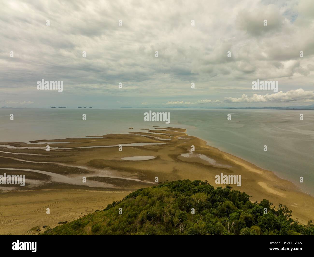 Drone aerial flight over bushy outcrop and patterns in the sand towards ...