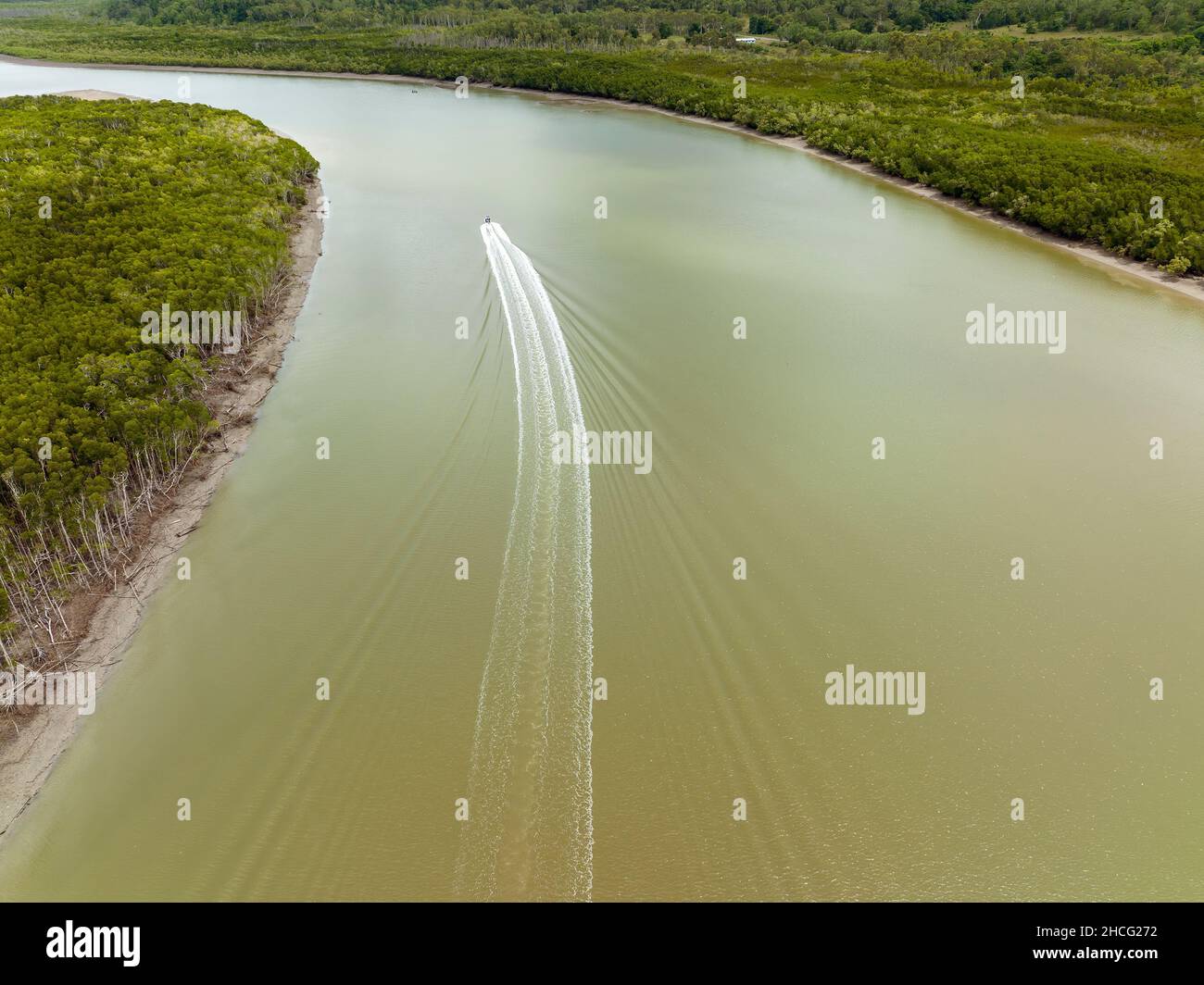 A power boat roaring up the river at speed leaving a wake behind ...