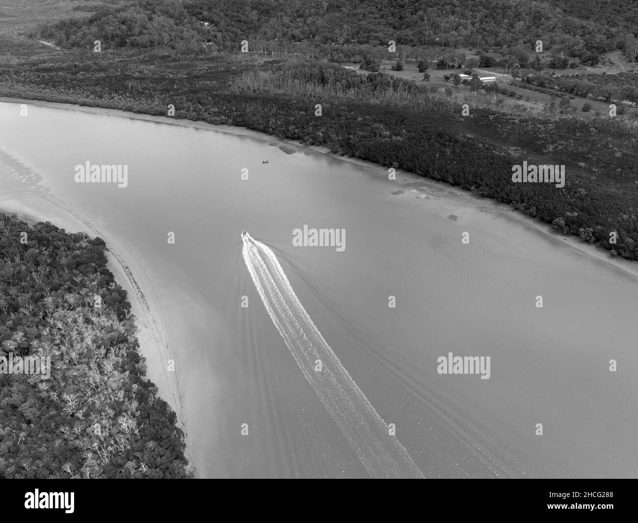 A power boat roaring up the river at speed leaving a wake behind ...