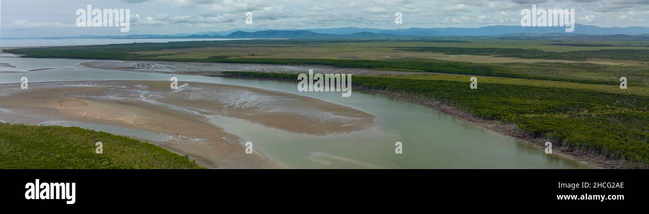 Panorama of a tidal river with sand bars showing and the banks lined ...