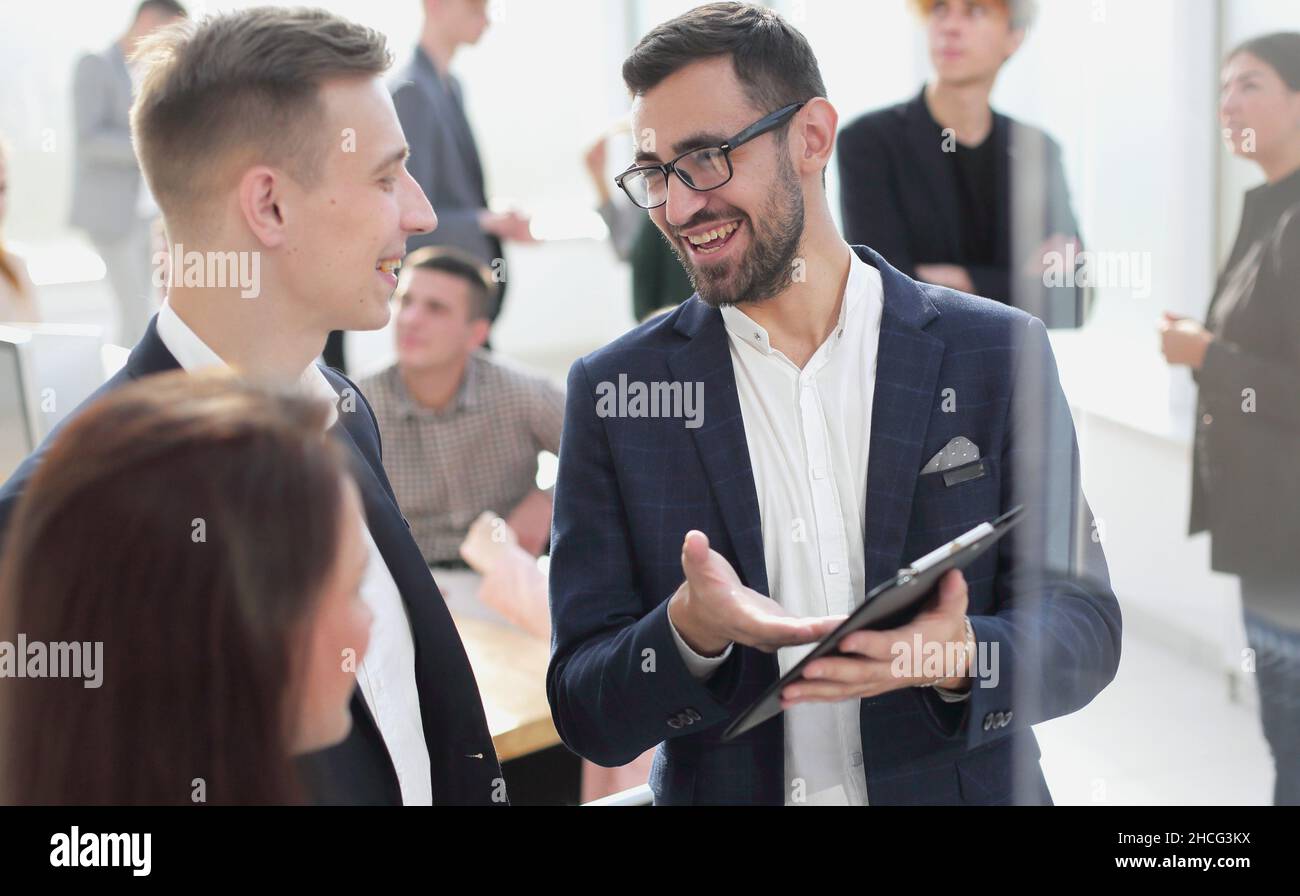colleagues discussing current tasks standing in the office Stock Photo ...
