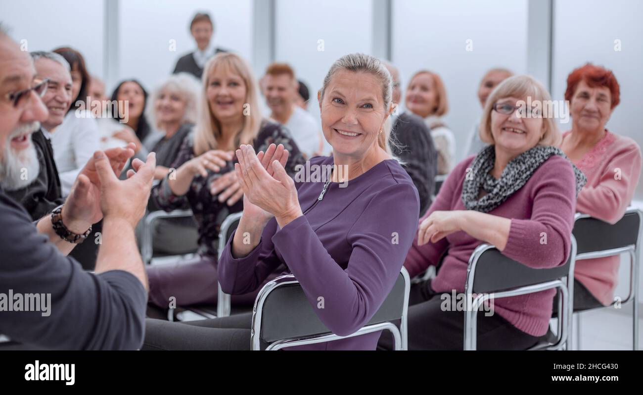 a group of elderly people are sitting in a circle clapping their hands ...