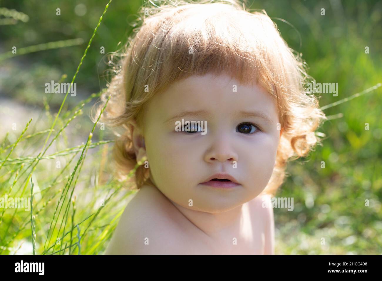 Happy baby at the park. Baby face close up. Funny little child closeup ...