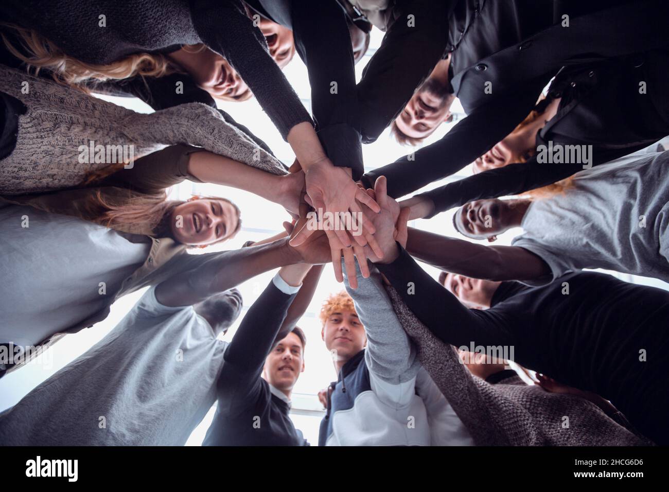 bottom view. group of happy young people making a tower out of their ...