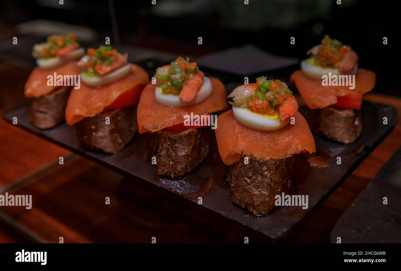 Traditional Spanish pintxos toast or tostada with smoked salmon and ...