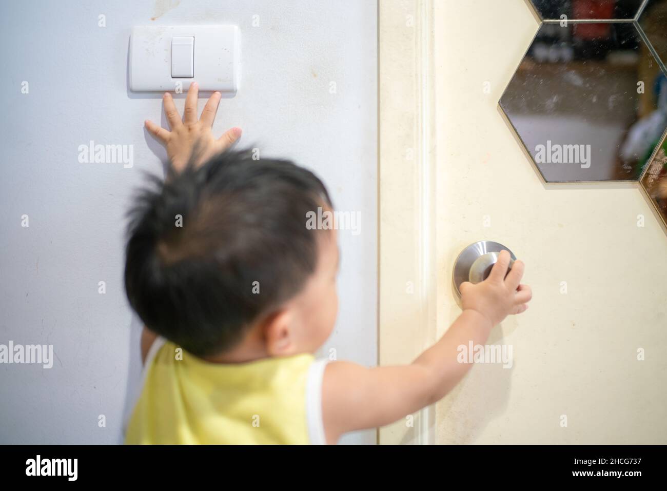 Baby boy playing electric socket lamp plug in room danger child Stock ...