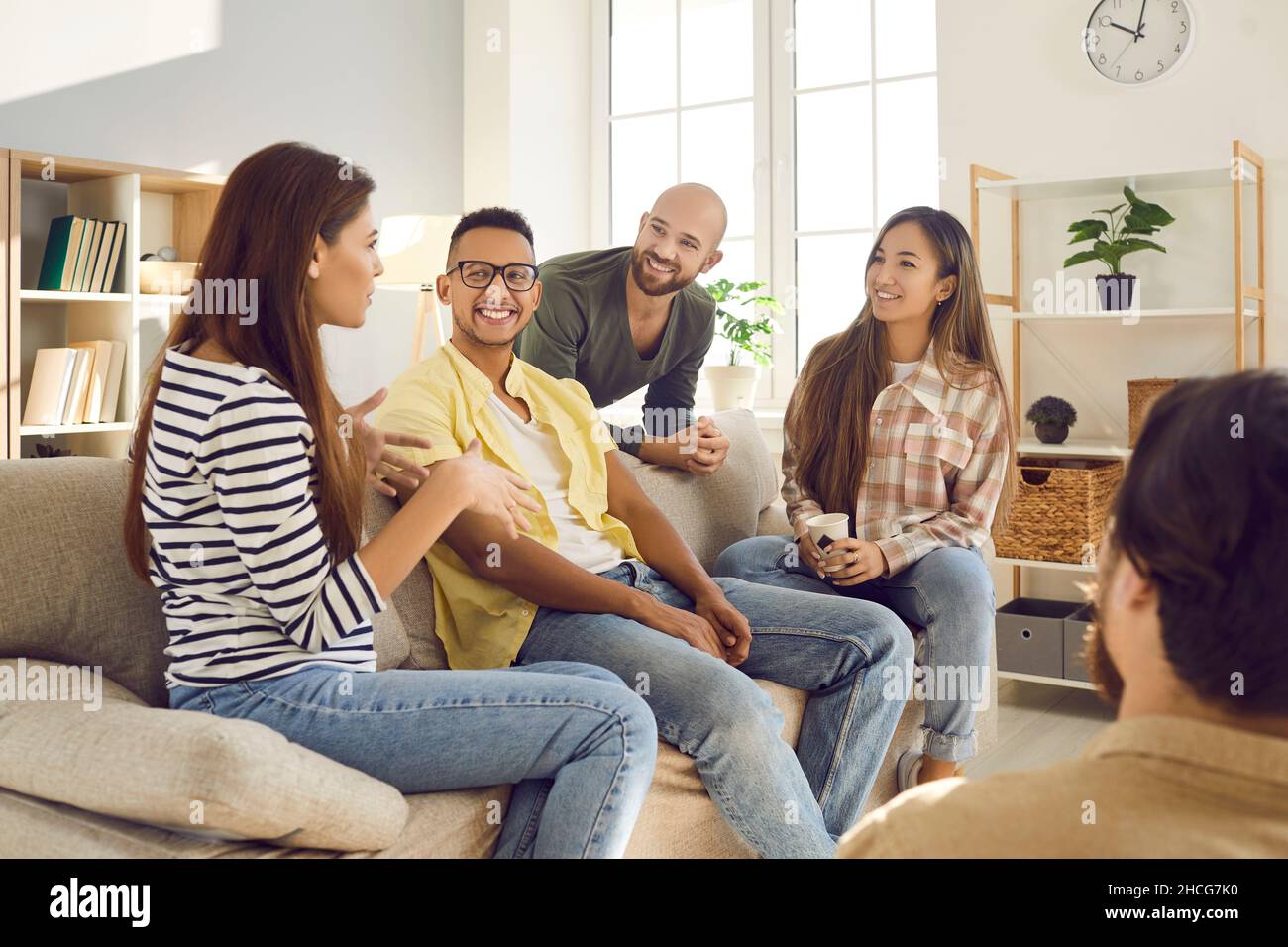 Group of smiling young multiethnic people talking during a friendly ...