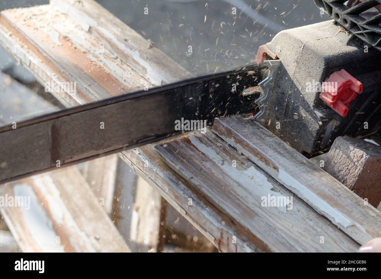 Black hand electric saw in operation. Worker sawing wood Stock Photo ...
