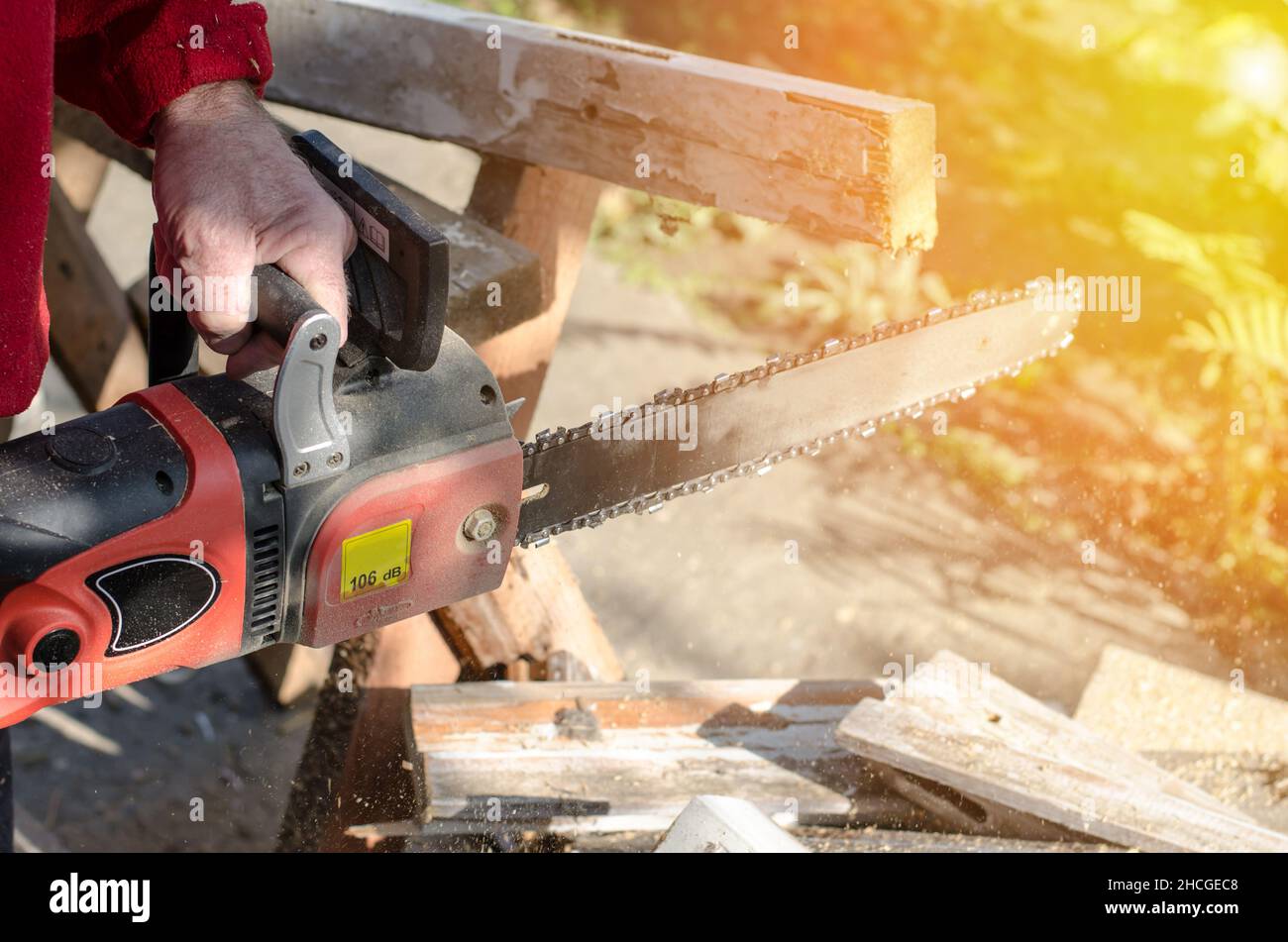 worker is sawing wood with a hand electric saw Stock Photo - Alamy