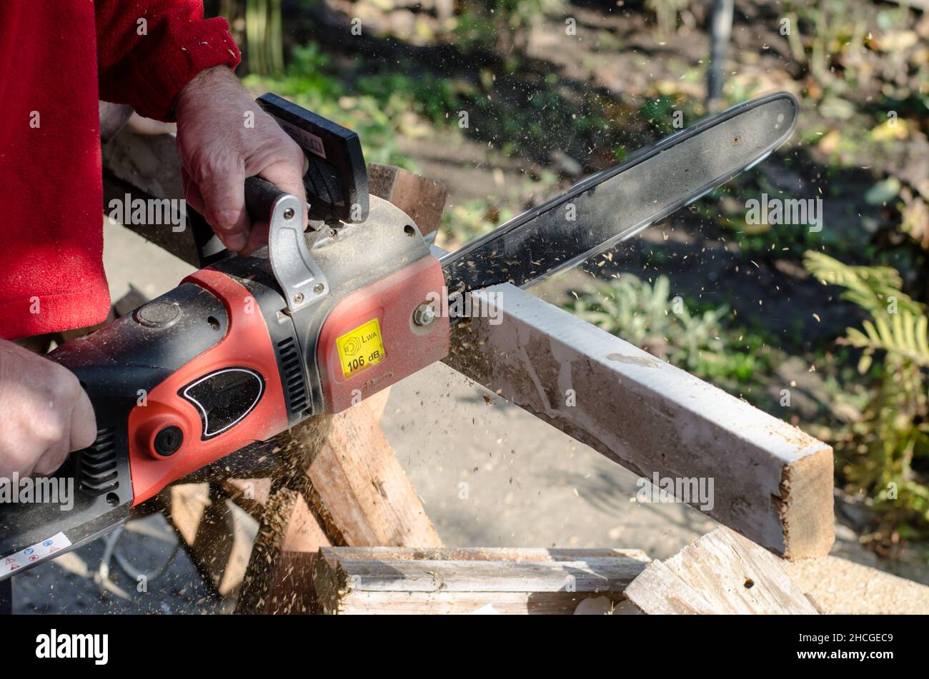 worker is sawing wood with a hand electric saw Stock Photo - Alamy