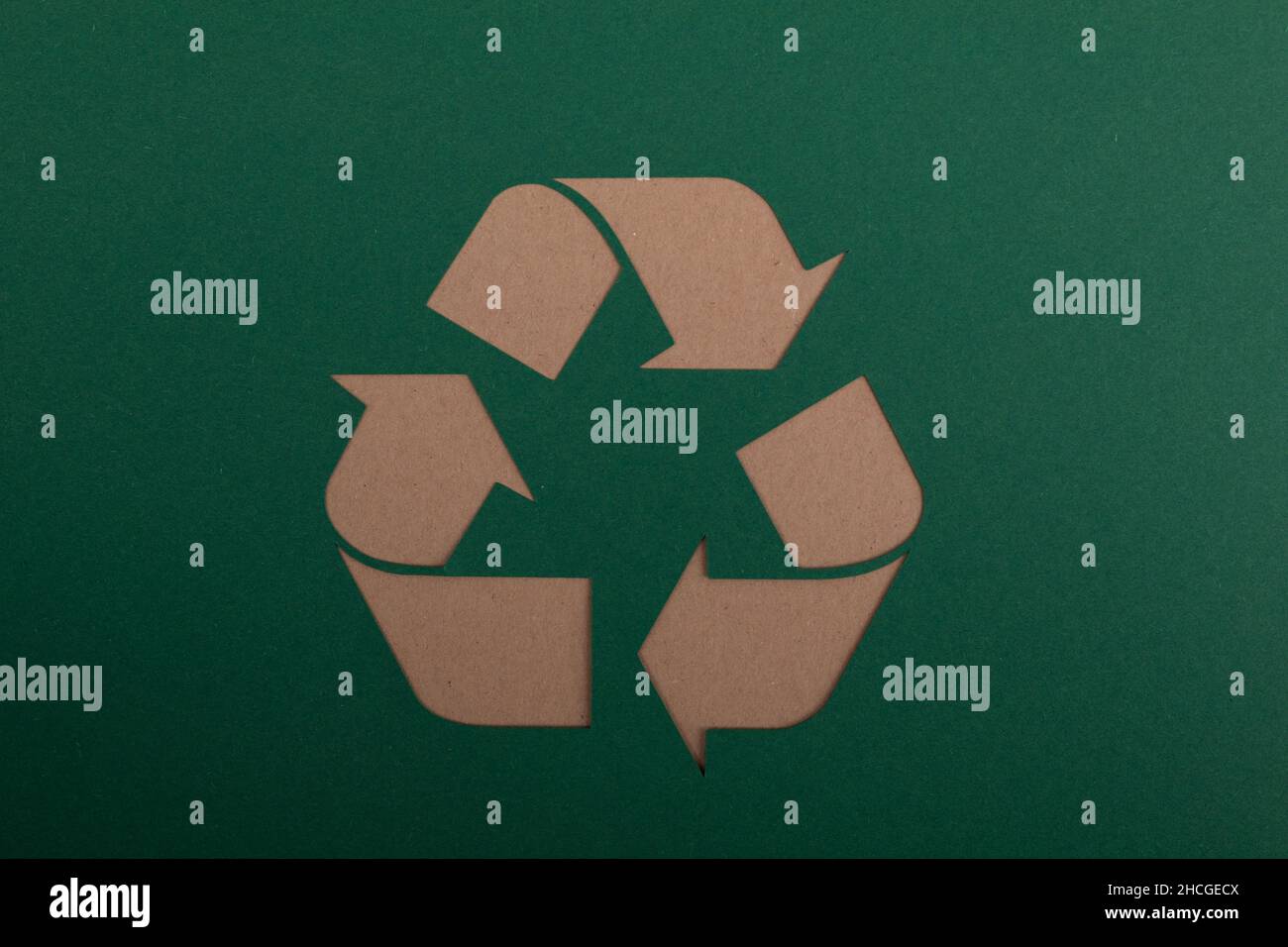 Closeup of the brown sign of recycling on the green paper. Eco-friendly ...