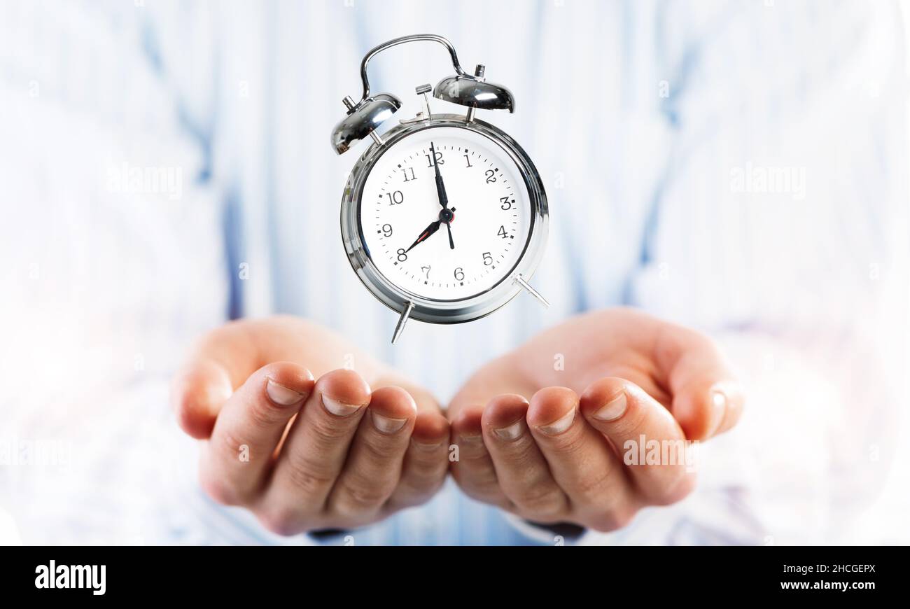 Concept of time management with clock in male palms. Mixed media Stock ...