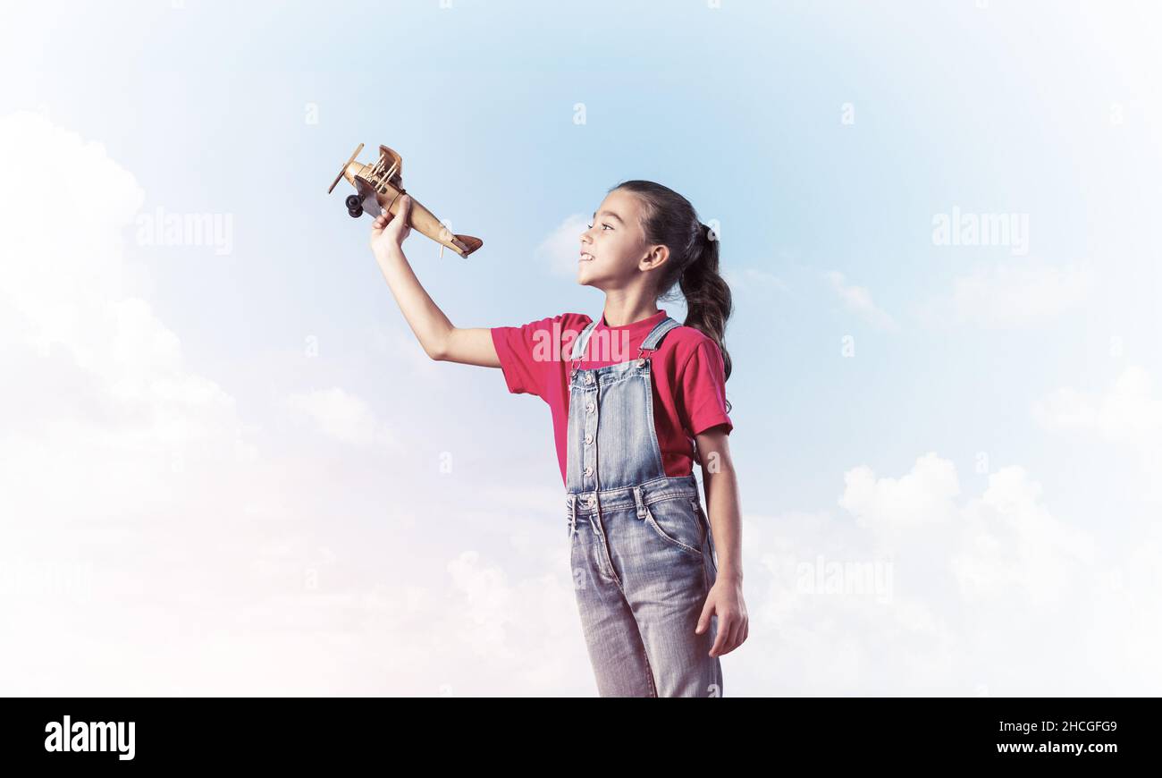Concept of careless happy childhood with girl dreaming to become pilot ...