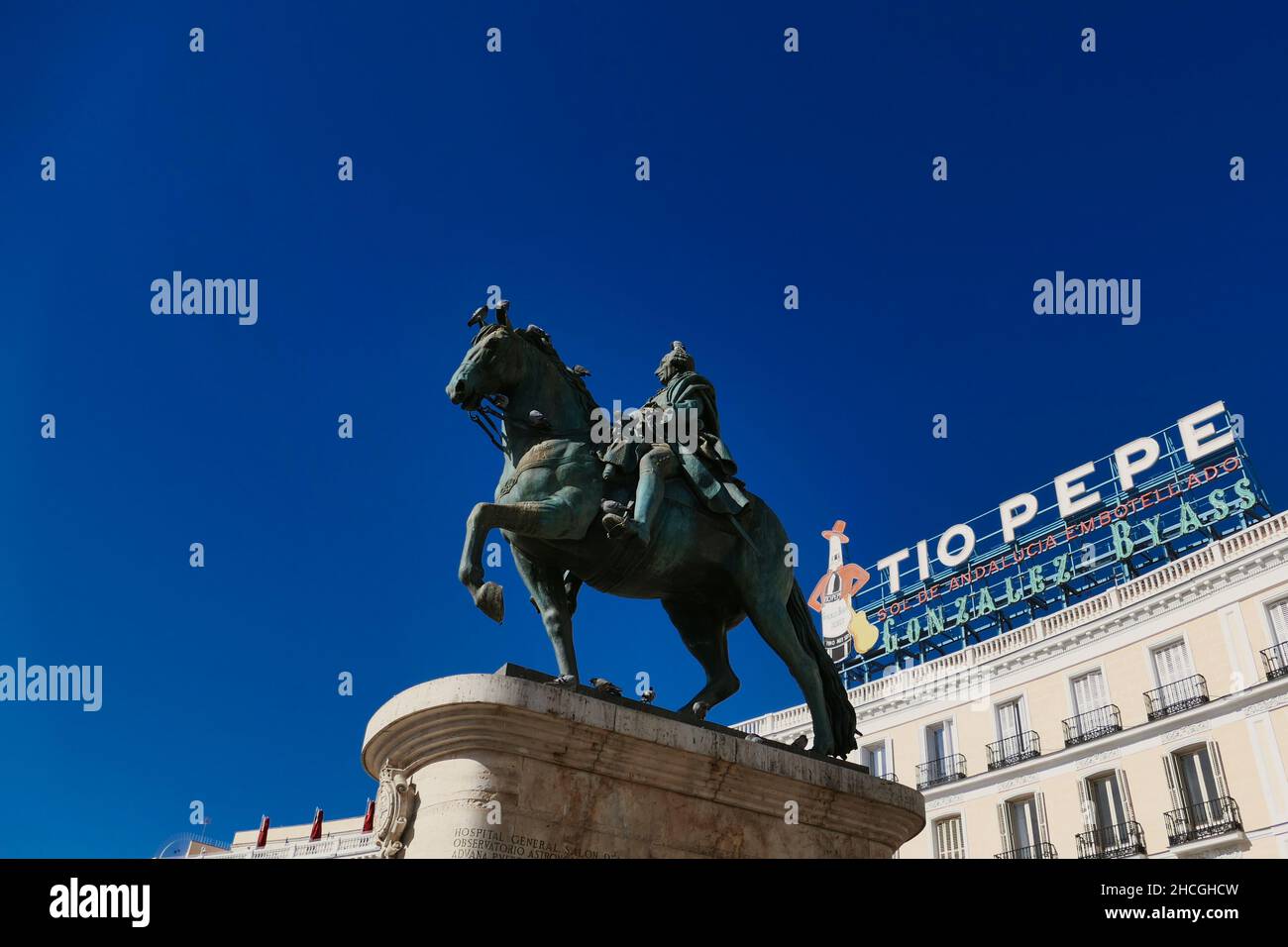 Low-angle shot of the Equestrian Statue of Charles III against a blue ...