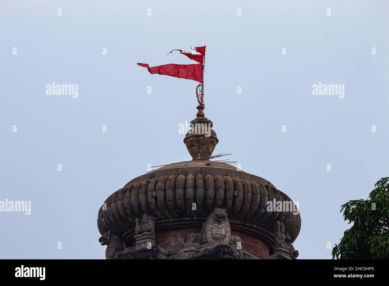 Beautiful shot of the top of a tower with red flag on it in Lingaraja ...
