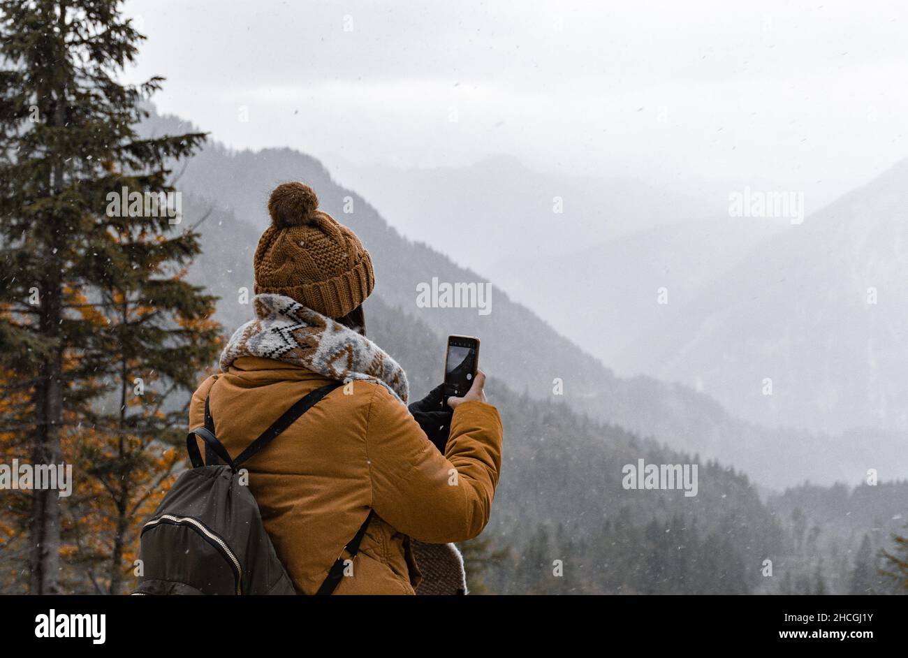 A scenic view of a Caucasian female taking photos with her phone of a ...