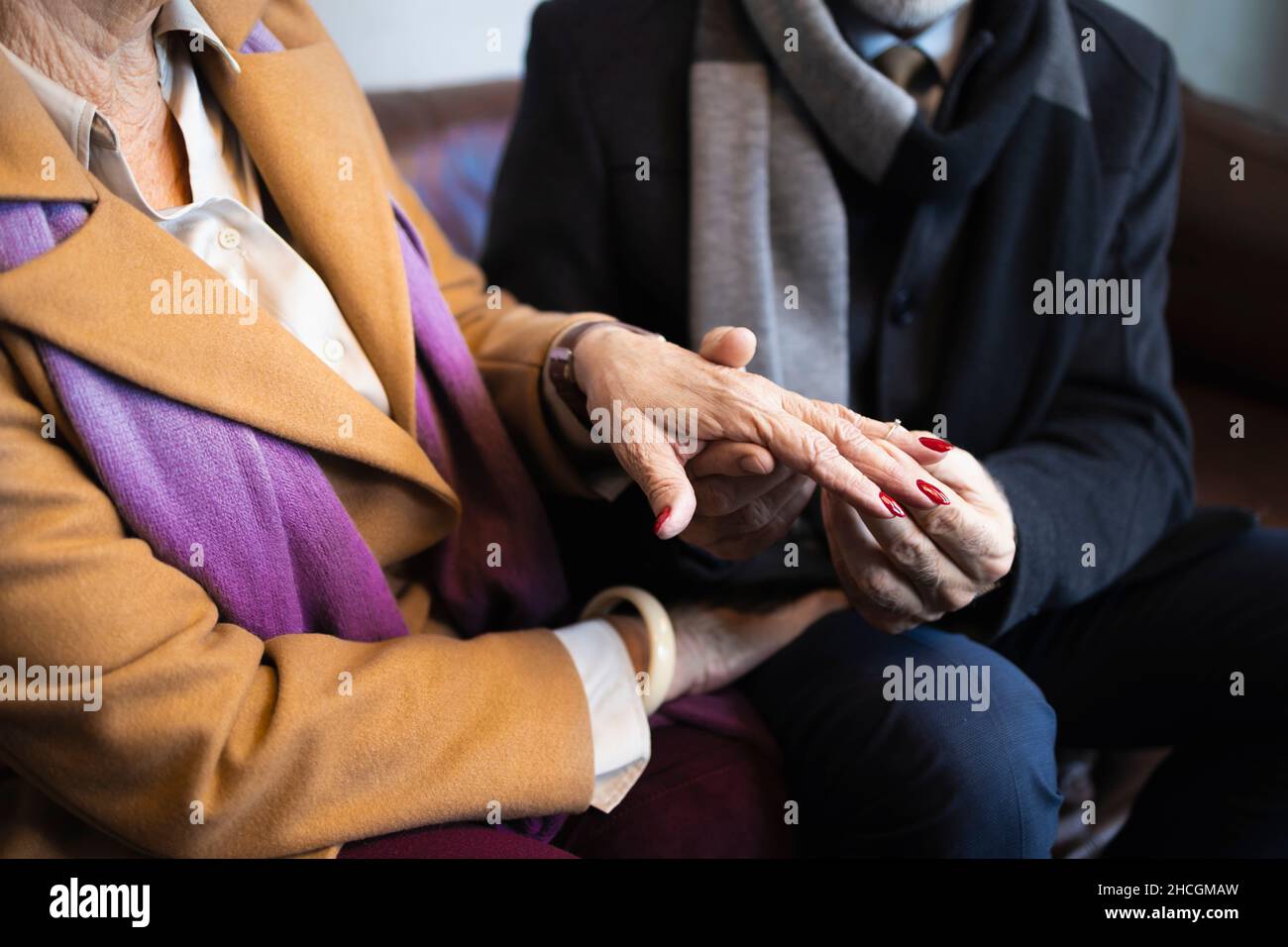 Older man putting a ring on hand of his woman Stock Photo - Alamy